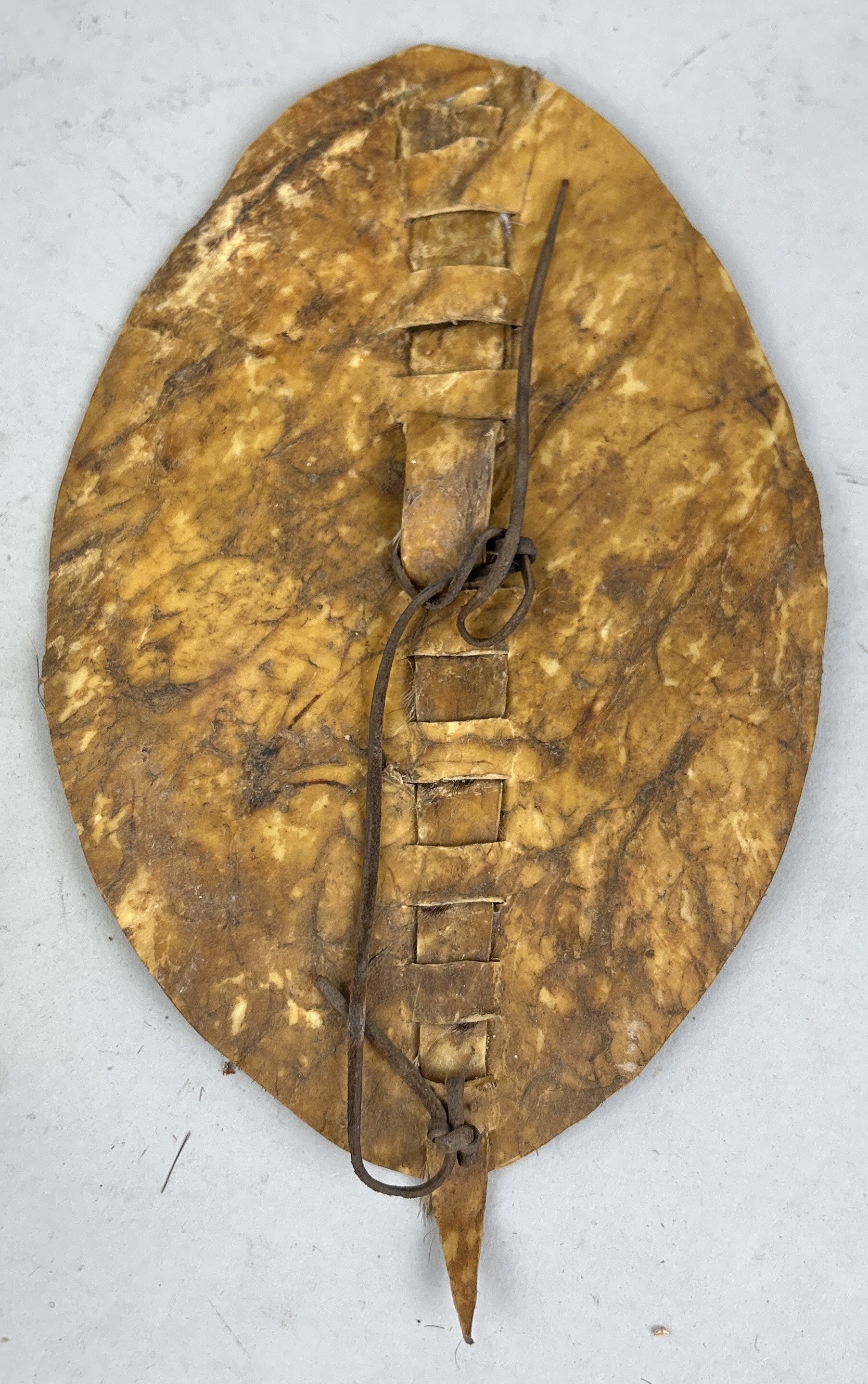 Lot 474 - A TRIBAL ANIMAL HIDE SHIELD FROM THE