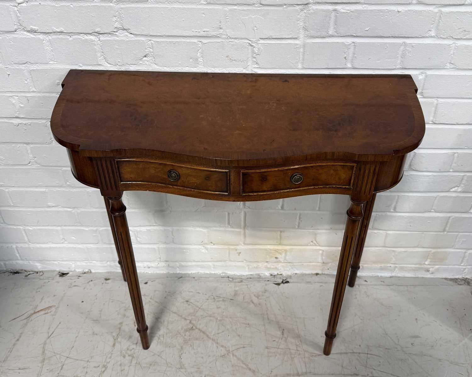 Lot 793 - A REPRODUCTION SERPENTINE CONSOLE TABLE
